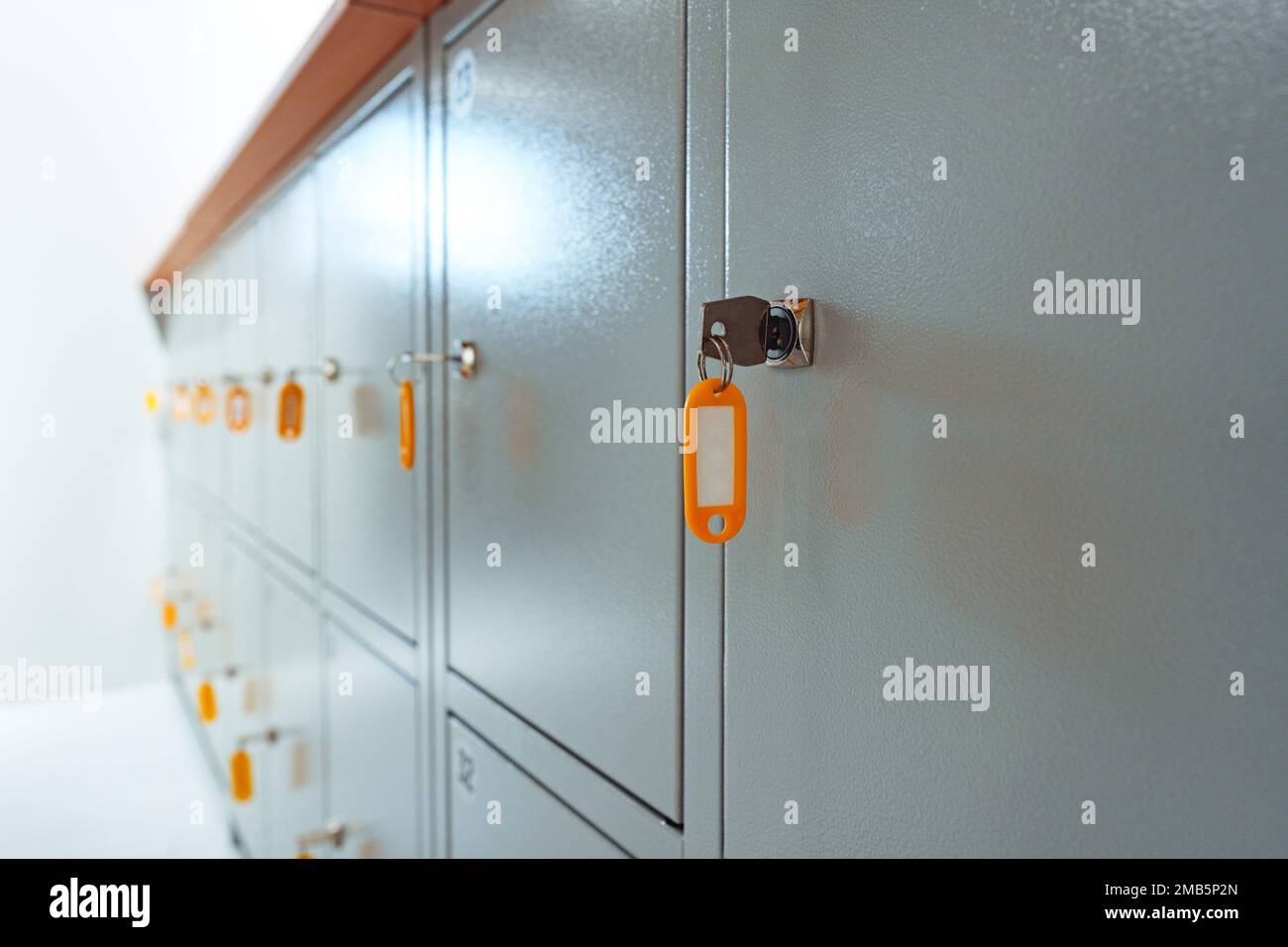 Gray locker with key for safety in public facility Stock Photo - Alamy
