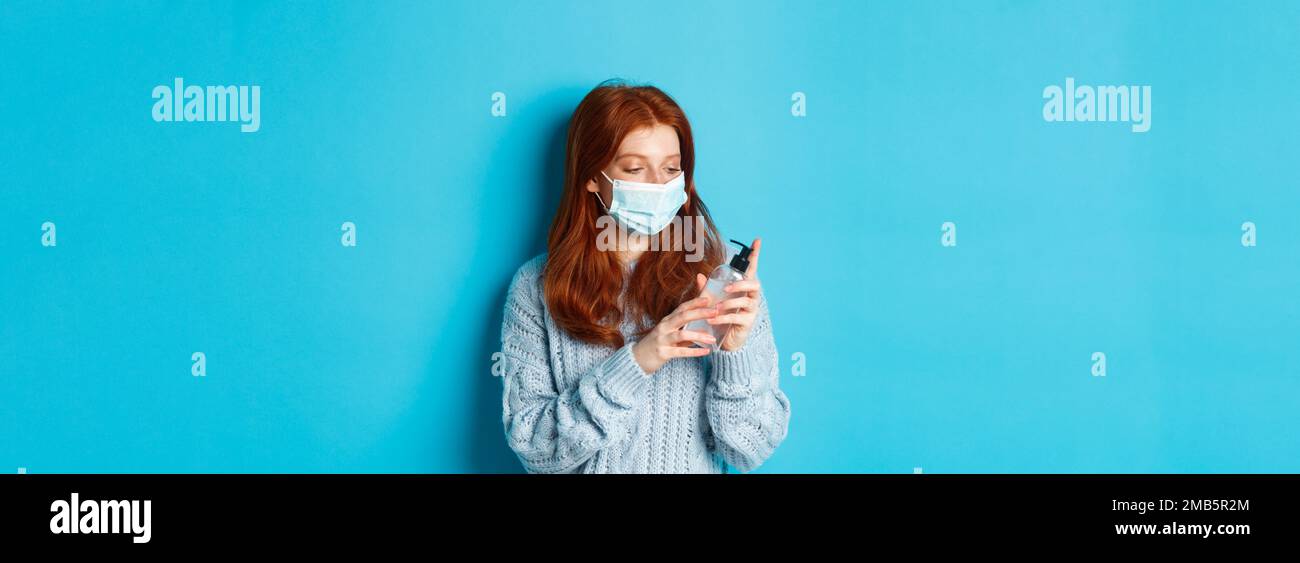 Winter, covid-19 and social distancing concept. Young redhead woman in ...