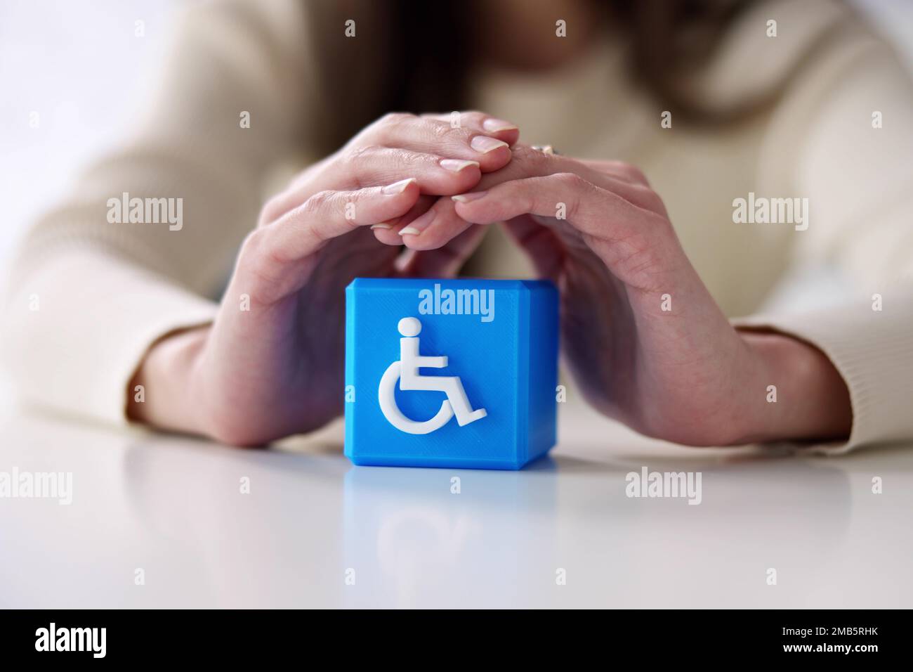 Person's Hand Protecting Blue Cubic Block With Disabled Icon Stock ...
