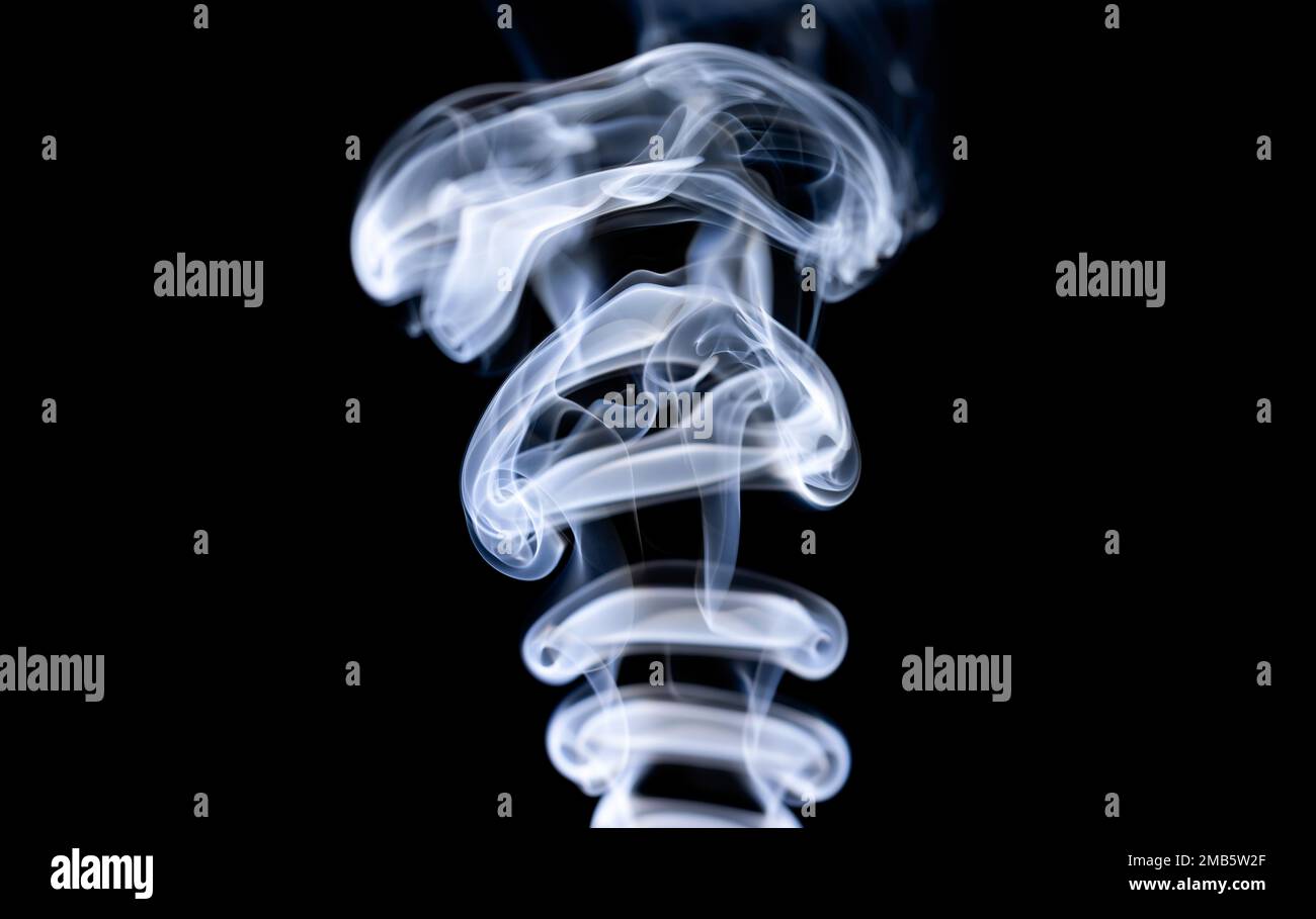 Pattern formed by smoke swirling round in front of a plain, black ...