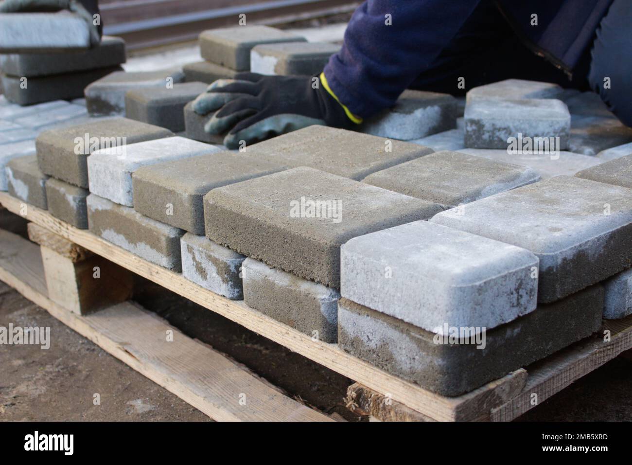 Defocus paver master. Man lays paving stones in layers. Garden brick ...