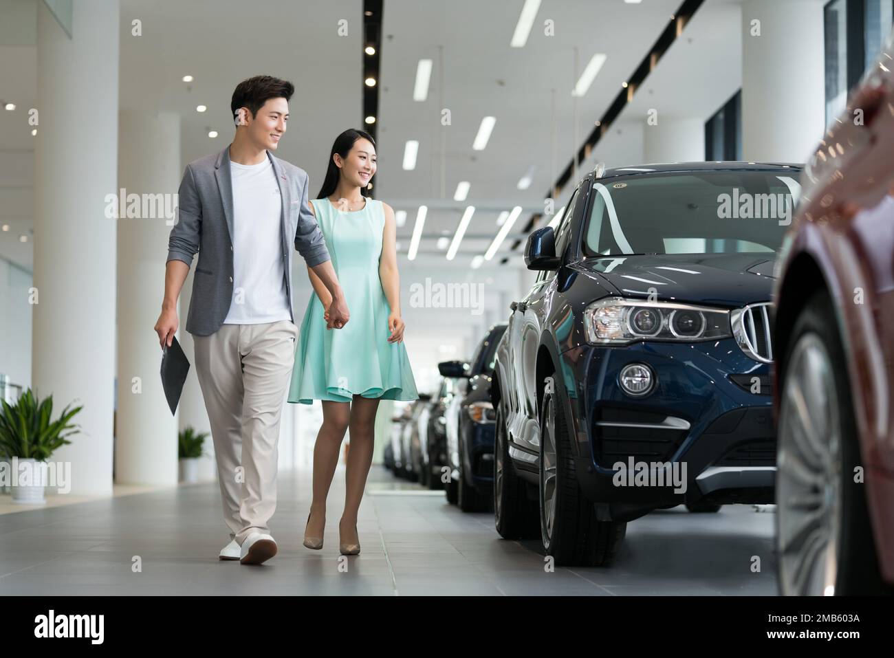 A young couple of choose and buy cars Stock Photo - Alamy