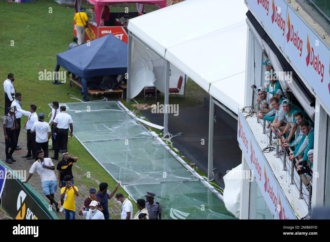 Australia's cricket team members look at a blown away spectator stand ...