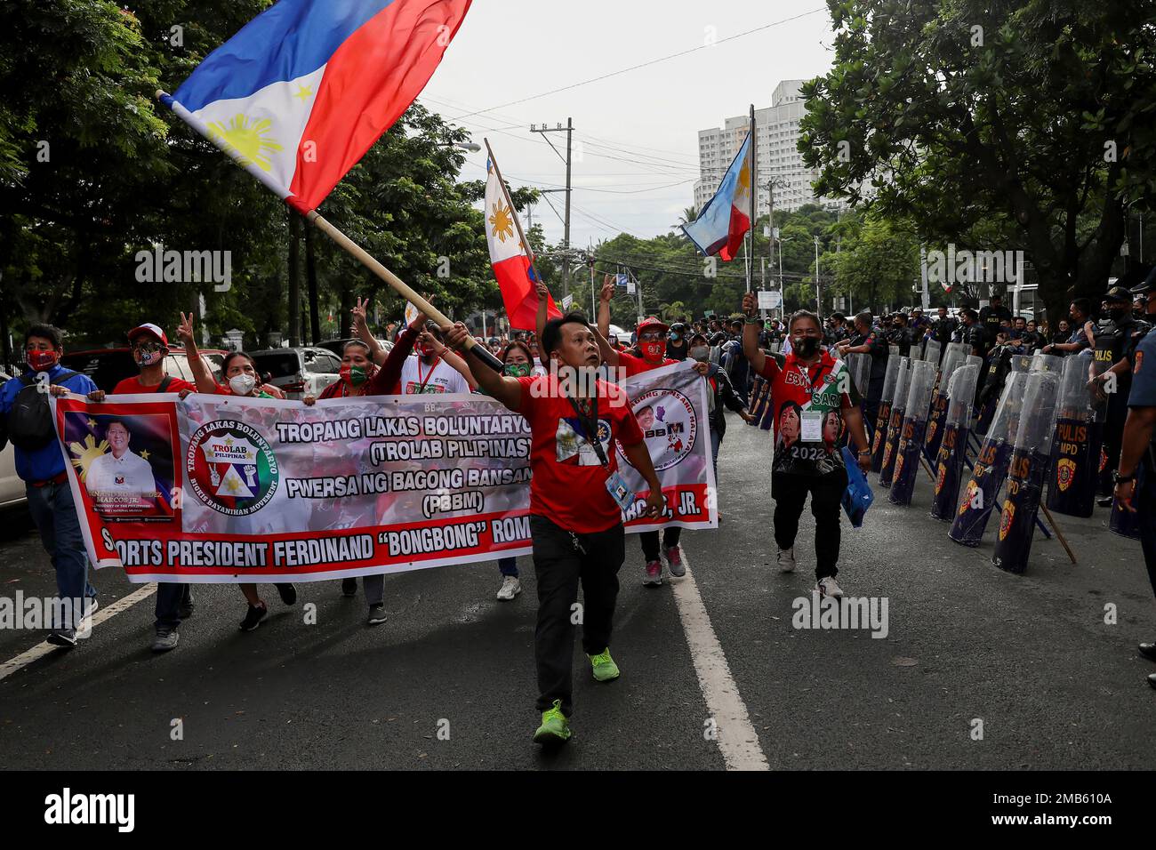 Supporters carry signs and wave flags as they march for the ...
