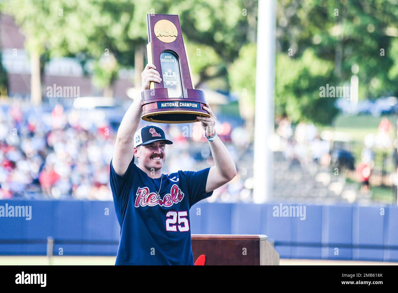 Mississippi first baseman Tim Elko holds up the trophy as the team ...