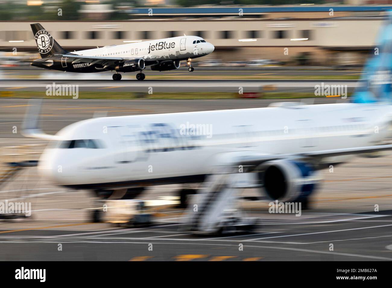 A JetBlue airplane lands at John F. Kennedy International Airport on ...