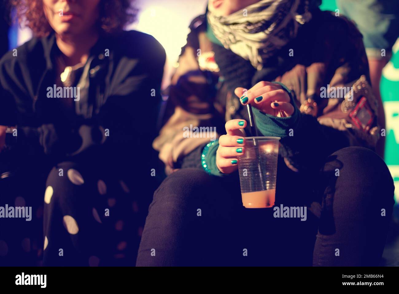 Pre-concert partying. two party-goers drinking at an outdoor festival ...