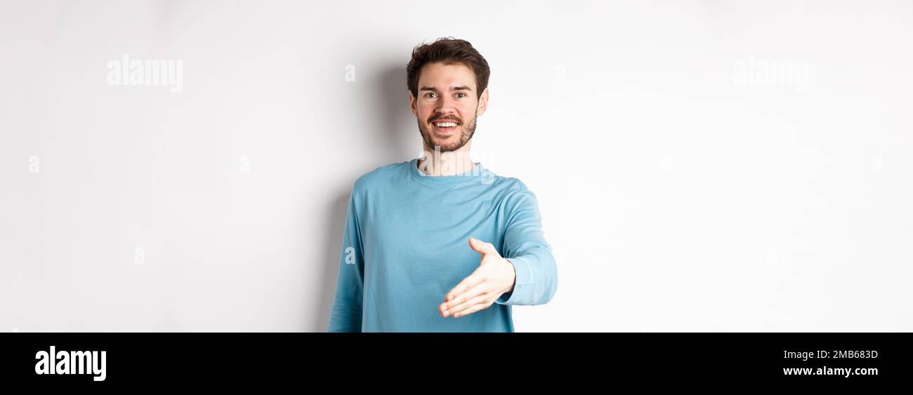 Friendly smiling man stretch out hand, saying hello and give arm for ...