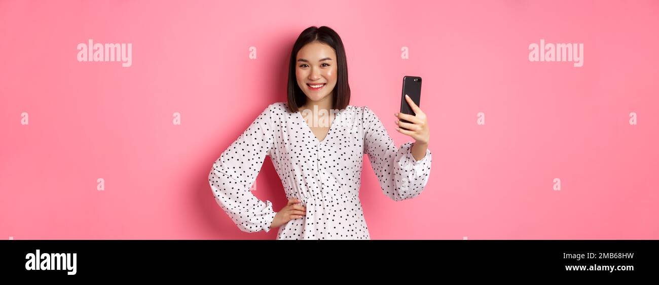 Beautiful asian girl using photo filters app and taking selfie on ...