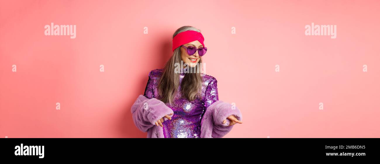 Fashionable asian senior woman dancing disco, wearing glittering shiny ...