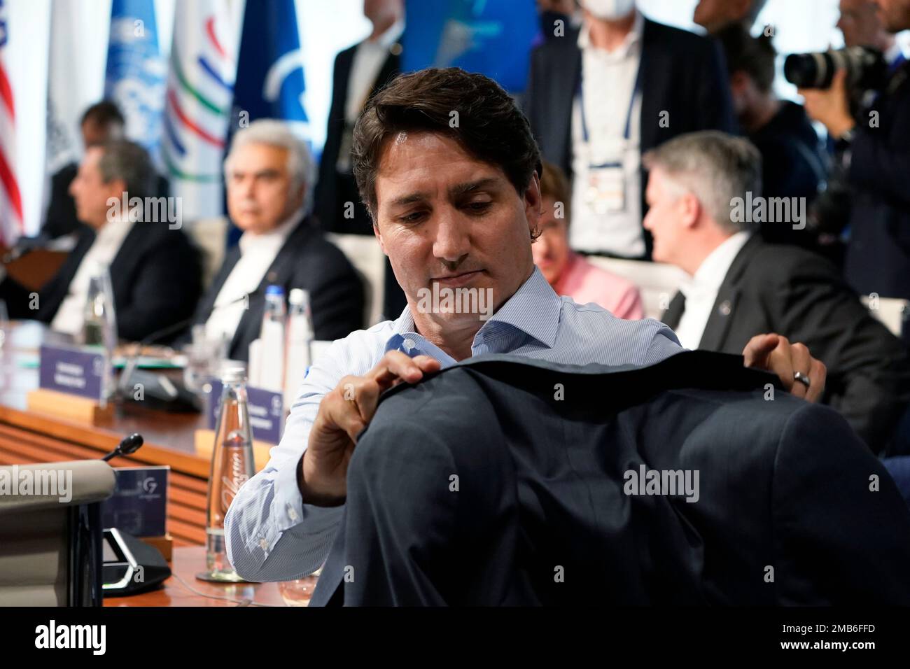Canada's Prime Minister Justin Trudeau hangs his coat on the back of ...