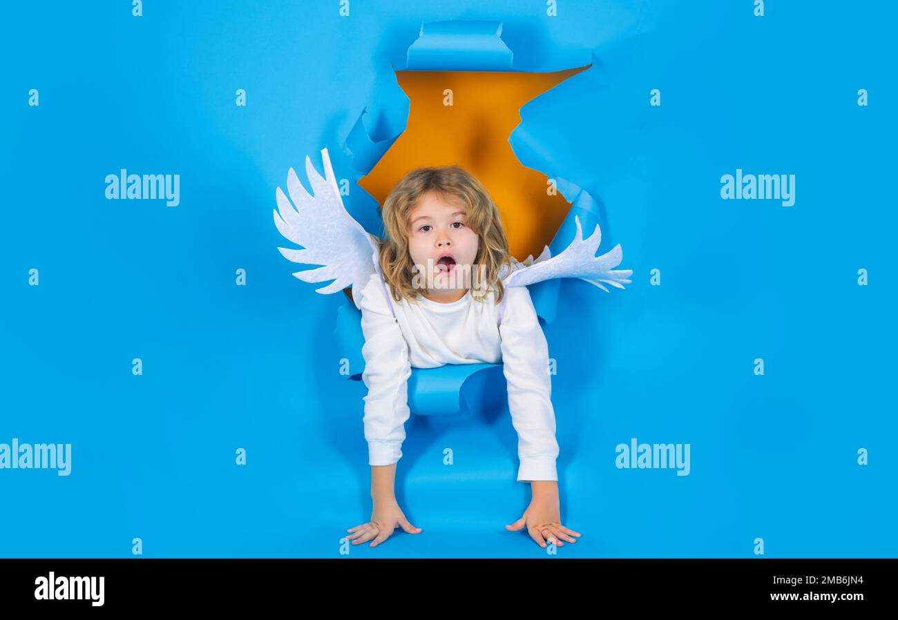 Valentines day. Surprised child angel in paper hole for banner ...