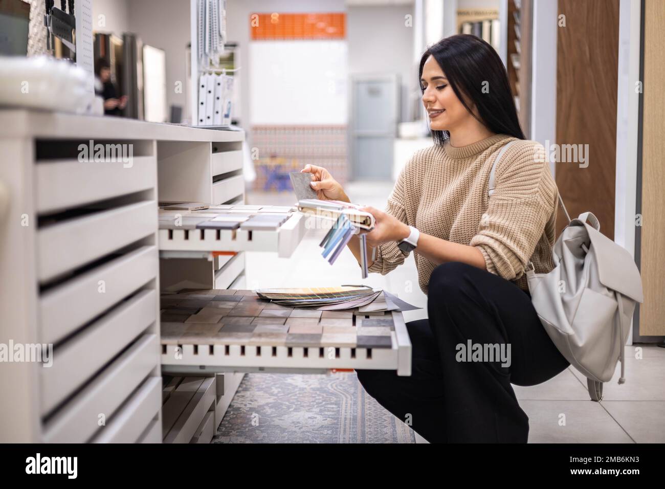 Beautiful woman brunette interior designer choosing color of epoxy ...