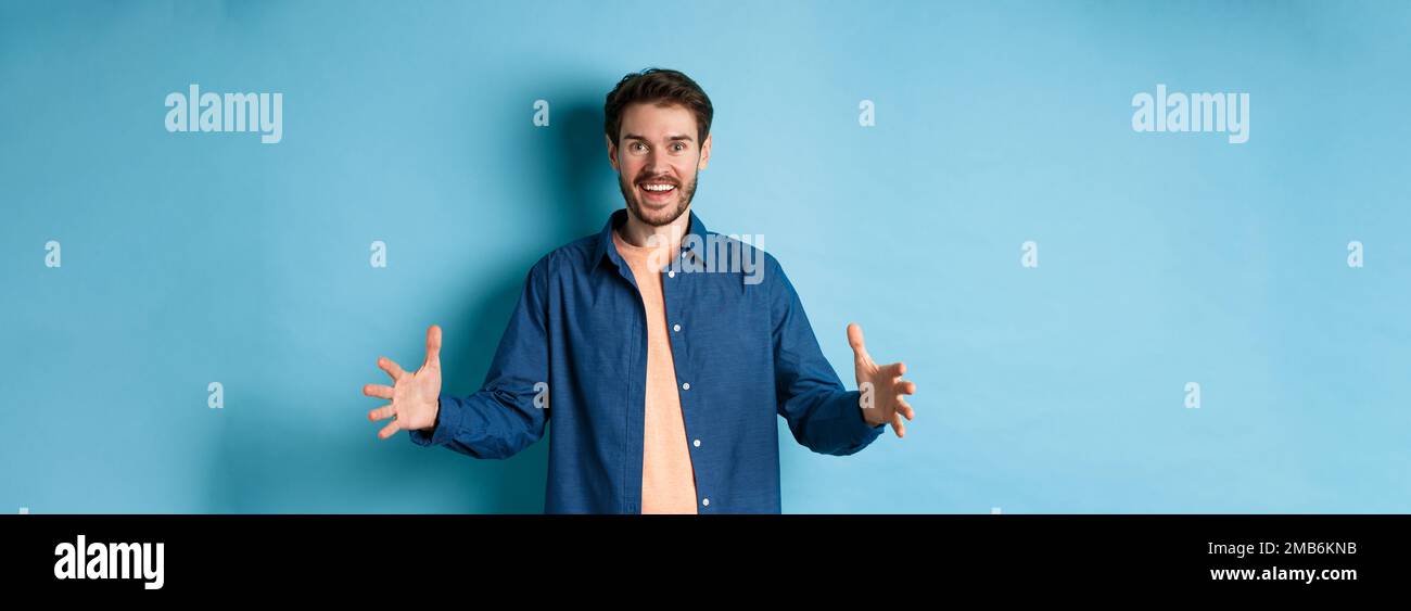 Happy smiling man showing big size object, shaping large thing and ...