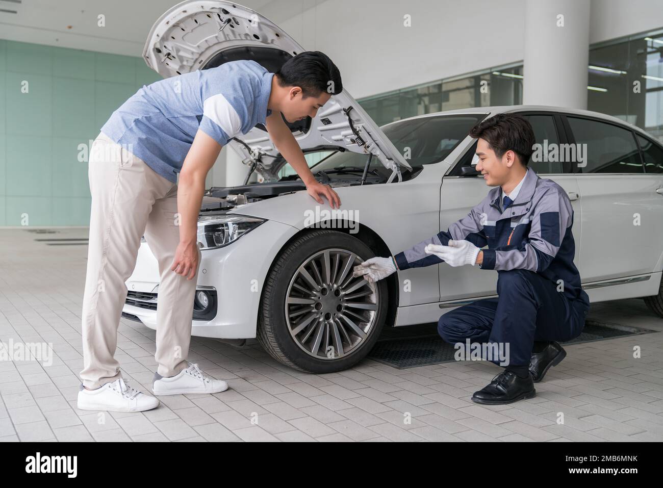 Repair shop mechanics of personnel with the customer Stock Photo - Alamy