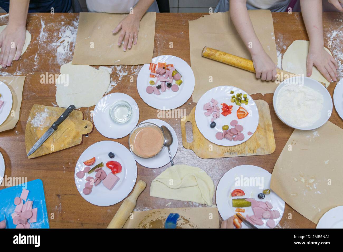 White plates with set of pizza ingredients and kitchen utensils stand ...