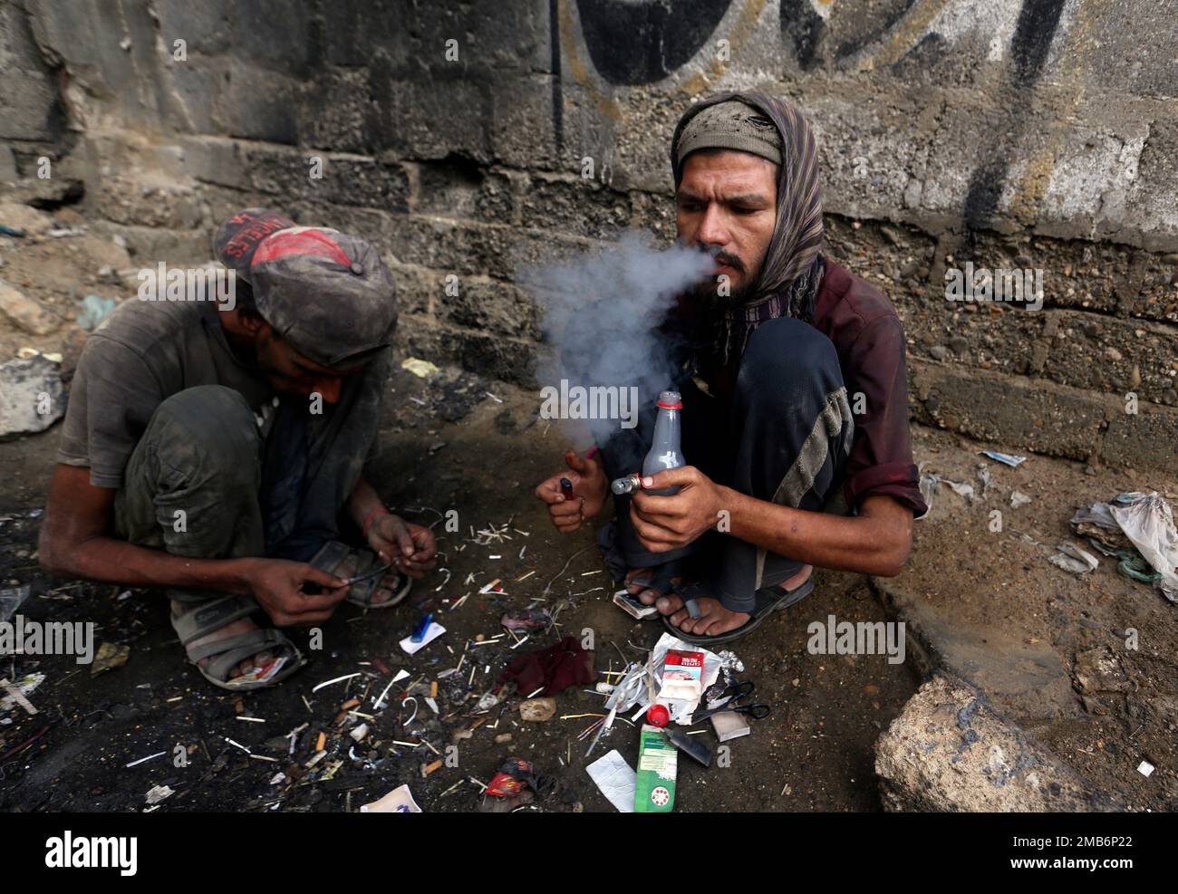 Pakistani drug addicts smoke heroin on a roadside in Karachi, Pakistan ...