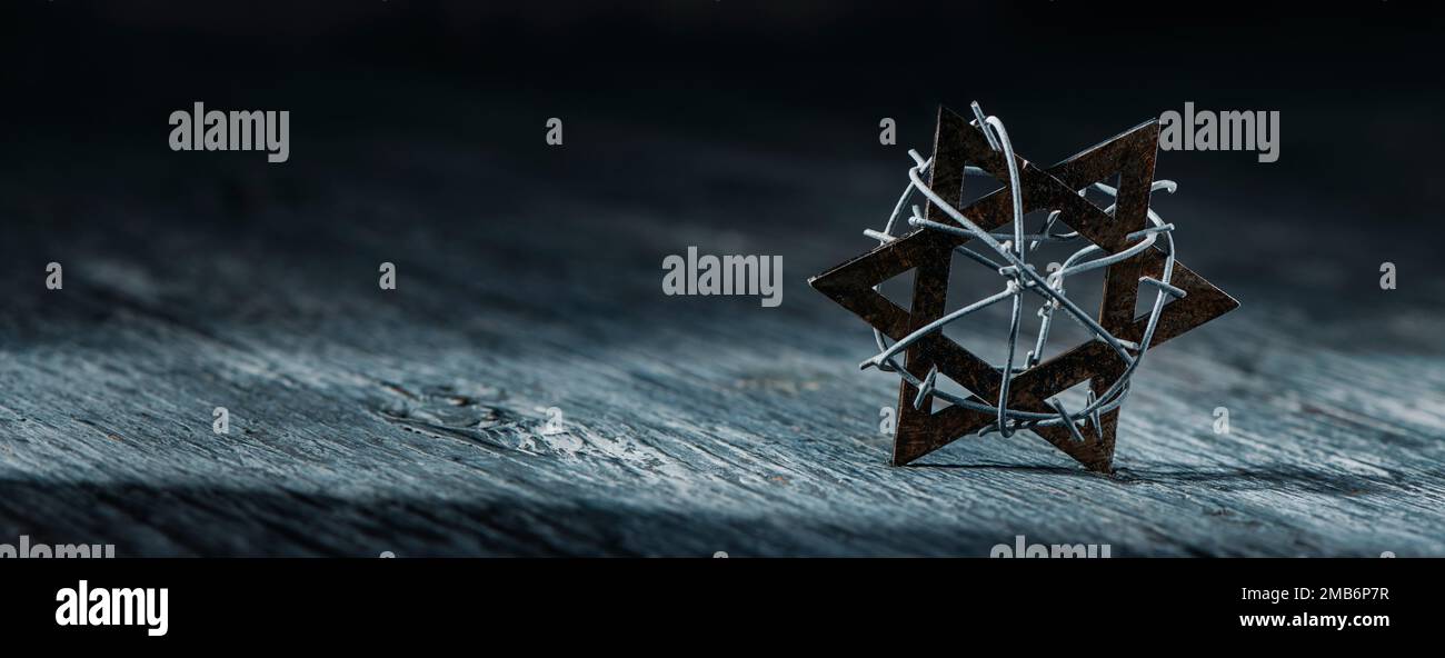 a star of david tied with some barbed wire placed on a gray rustic ...