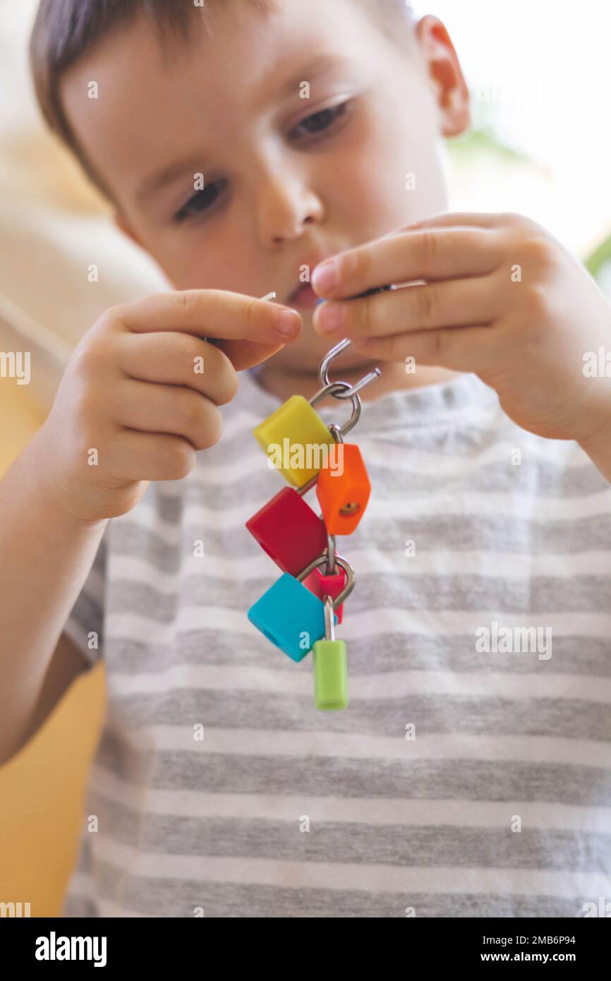 The child works with Montessori material with colored locks. Picks up ...