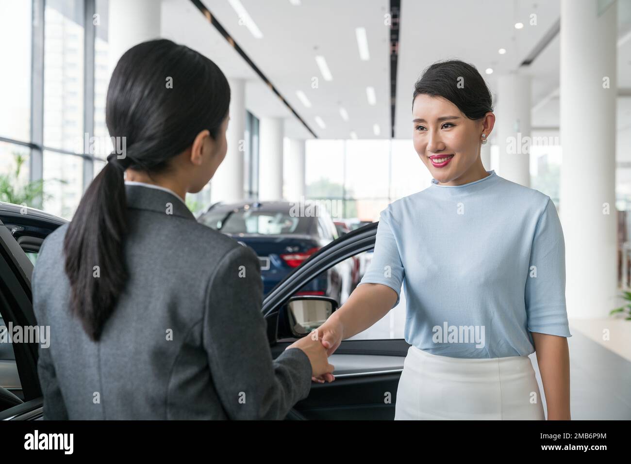 Young woman of choose and buy cars Stock Photo - Alamy
