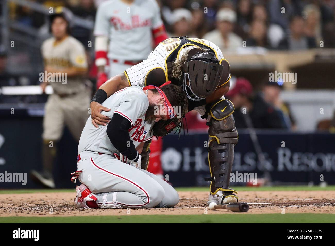 Philadelphia Phillies' Bryce Harper, bottom, reacts after being hit by ...
