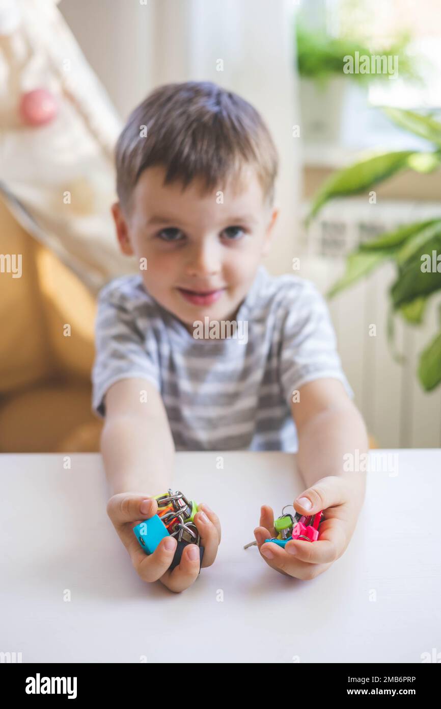 The child works with Montessori material with colored locks. Picks up ...