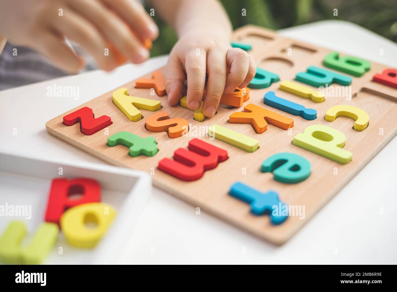 Male kid playing with wooden eco friendly alphabet letters board on ...