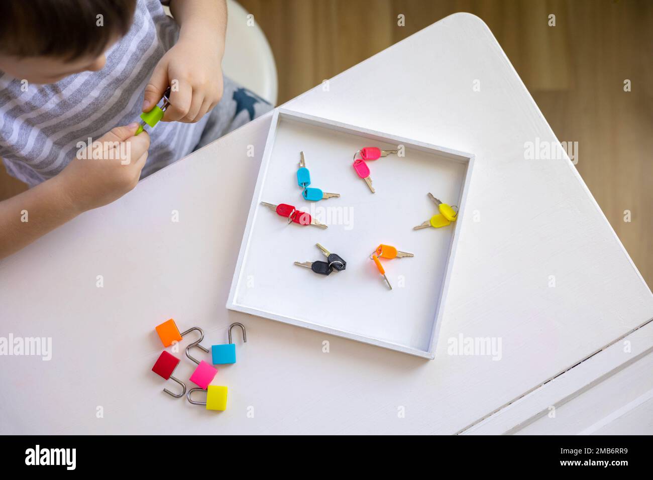 The child works with Montessori material with colored locks. Picks up ...