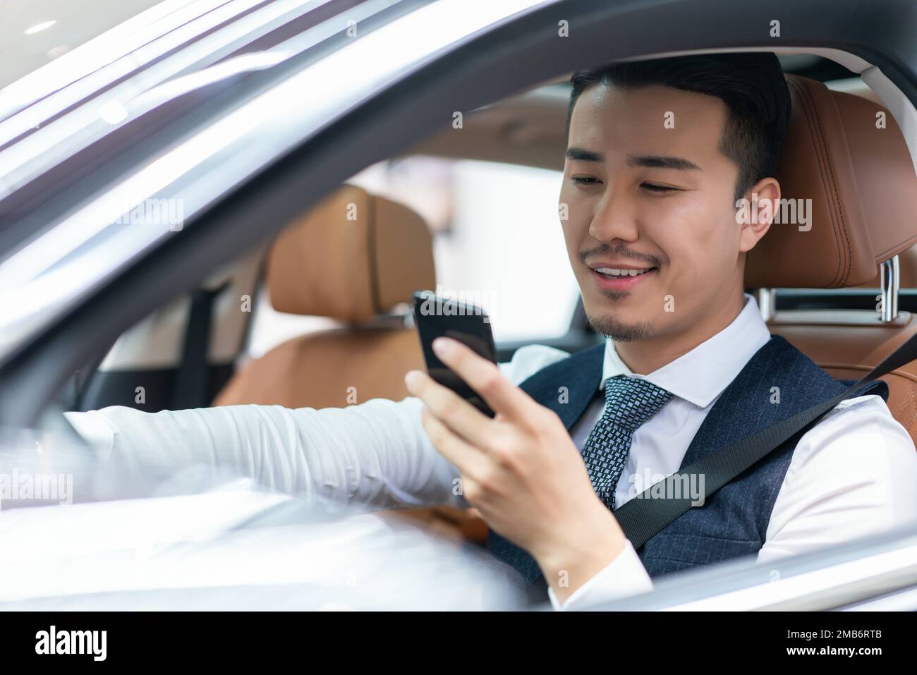 Business man in the car to use mobile phones Stock Photo - Alamy