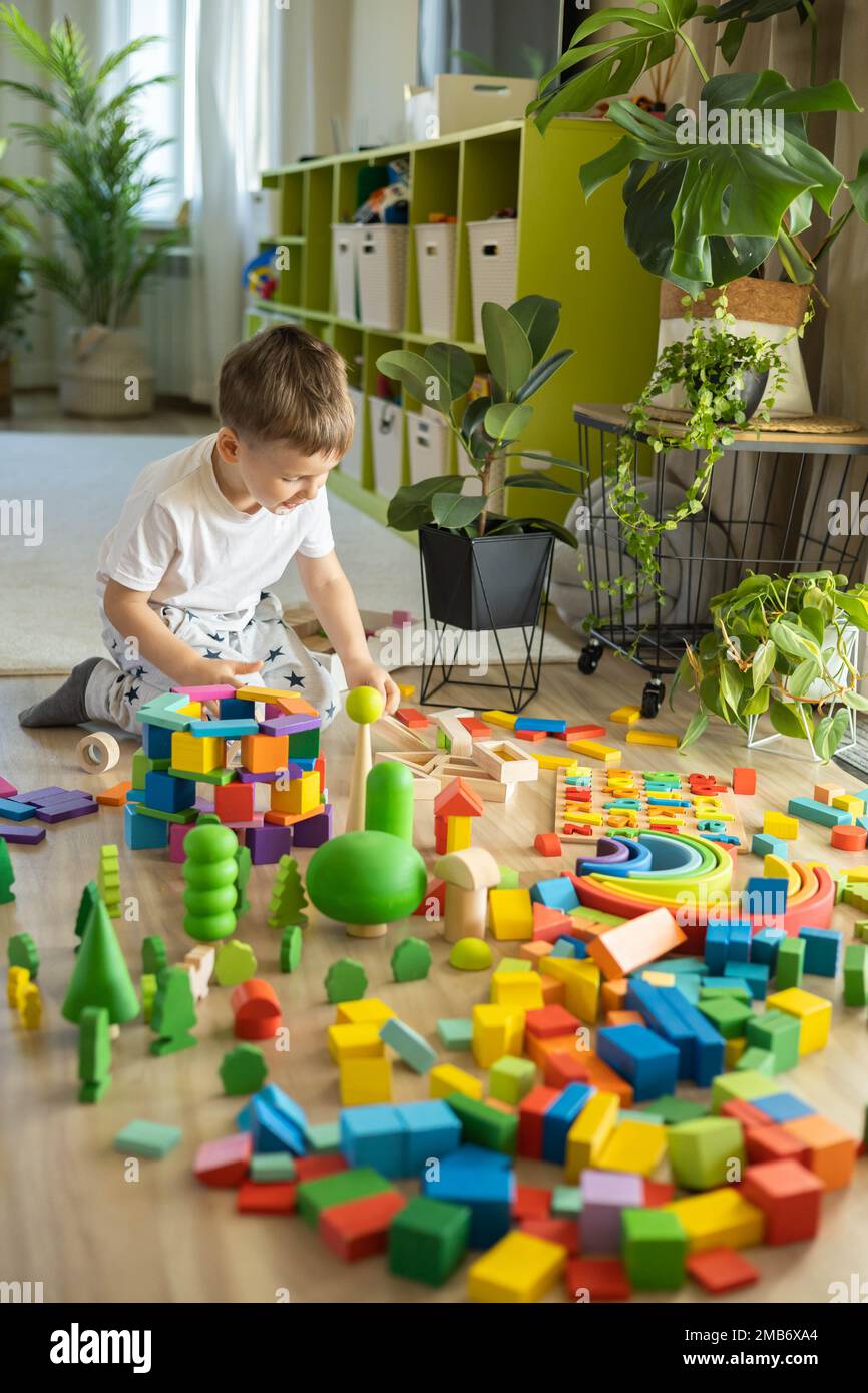 Confident male kid building fortress tower architecture and forest with ...