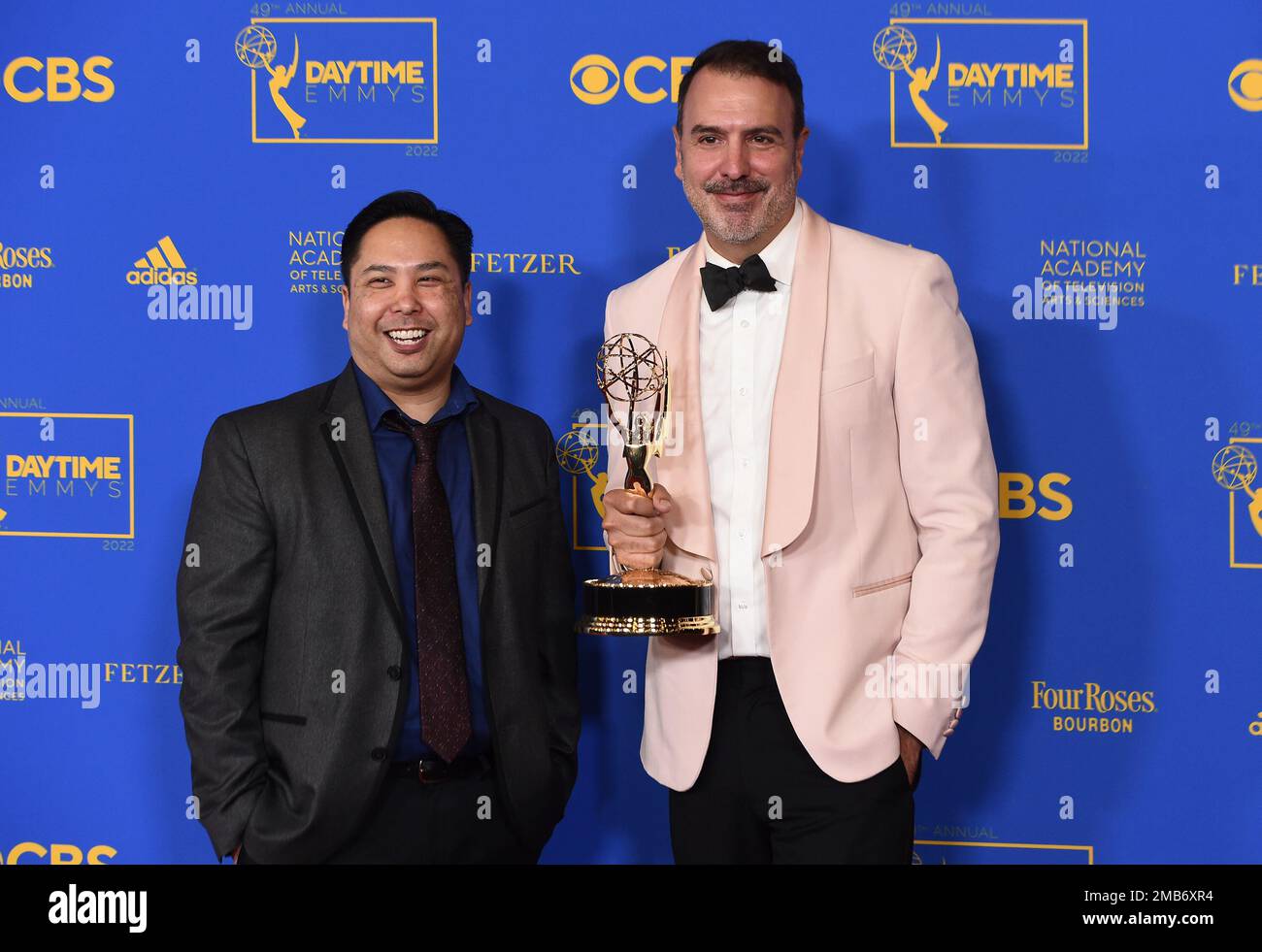 Ryan Quan, left, and Ron Carlivati pose in the press room with the award for outstanding writing ...