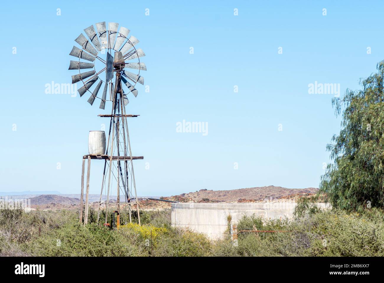 A typical Karoo landscape, with a windmill, water tank and dam, on road ...