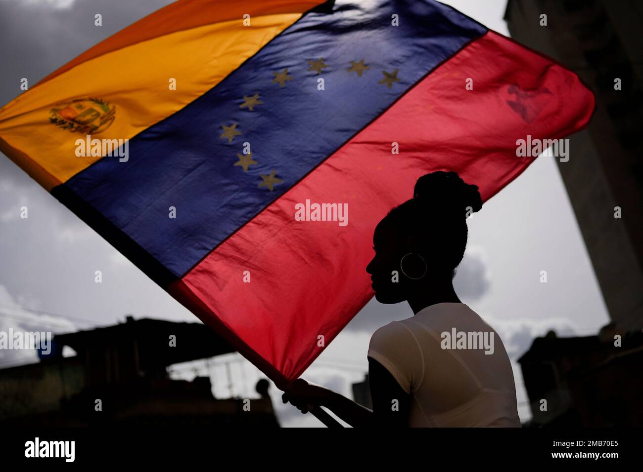 A woman holds a Venezuelan flag during the Saint John the Baptist feast ...