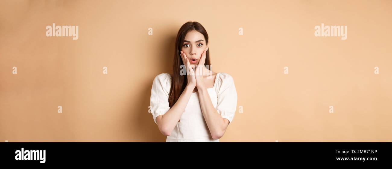 Wow unbelievable. Impressed young woman gasping and looking astonished ...