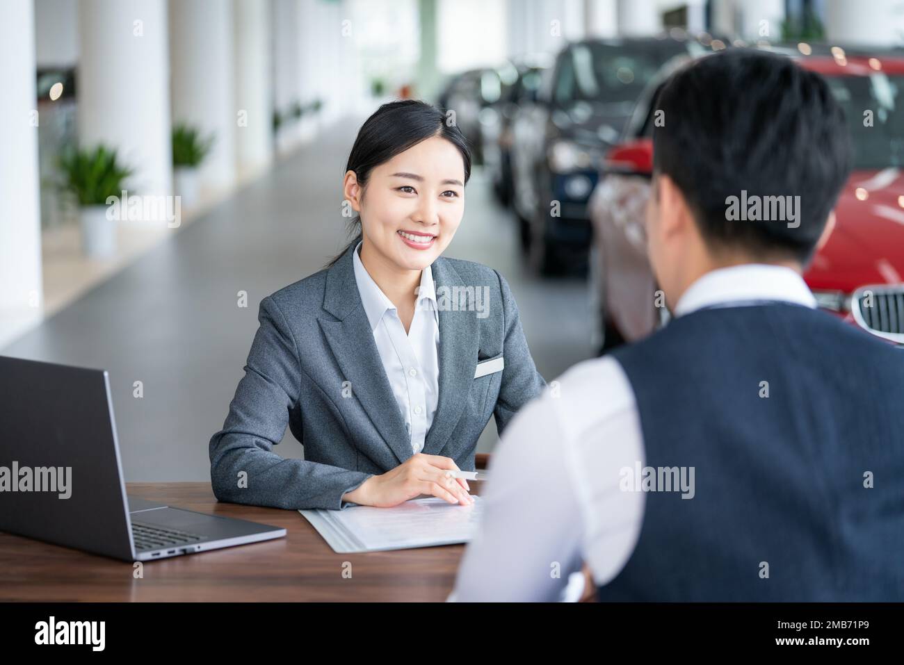 A young female sales with clients Stock Photo - Alamy