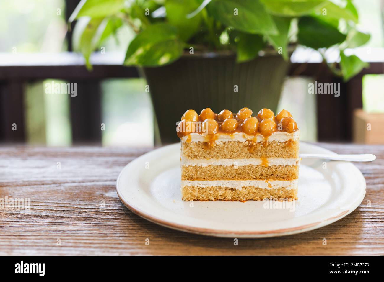 Macadamia caramel cake topping with macadamia nuts with coffee on table ...