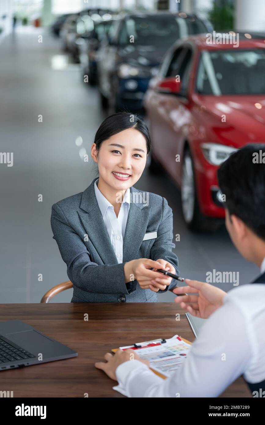 A young female sales with clients Stock Photo - Alamy