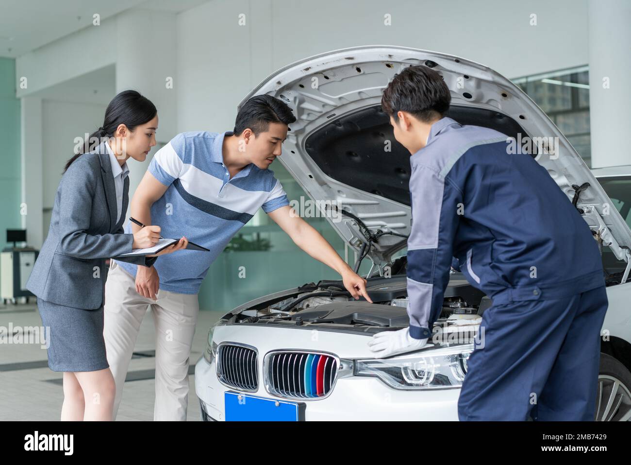 Repair shop mechanics of personnel with the customer Stock Photo - Alamy