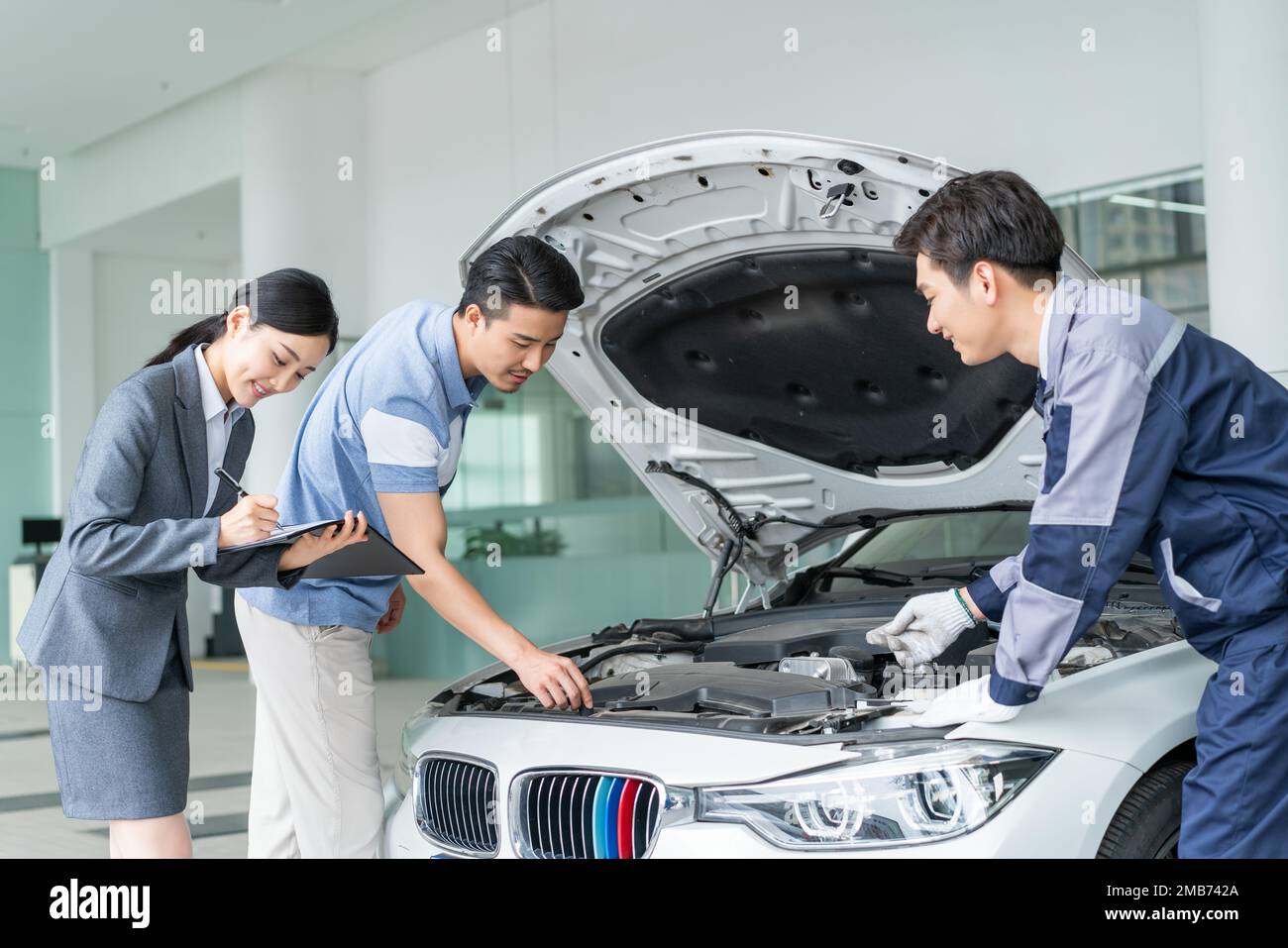 Repair shop mechanics of personnel with the customer Stock Photo - Alamy