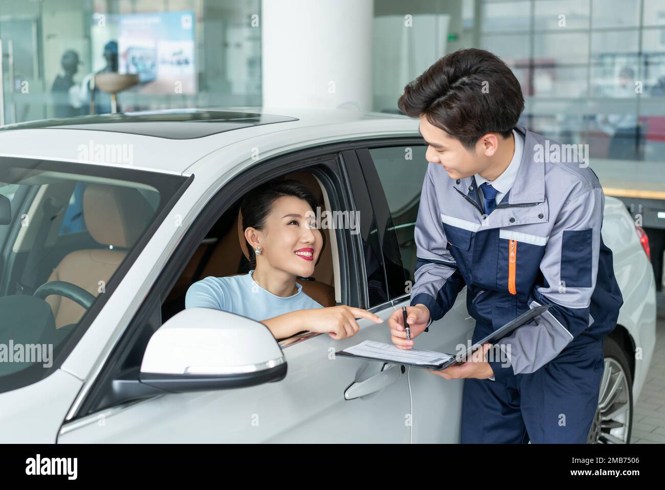 Repair shop mechanics of personnel with the customer Stock Photo - Alamy