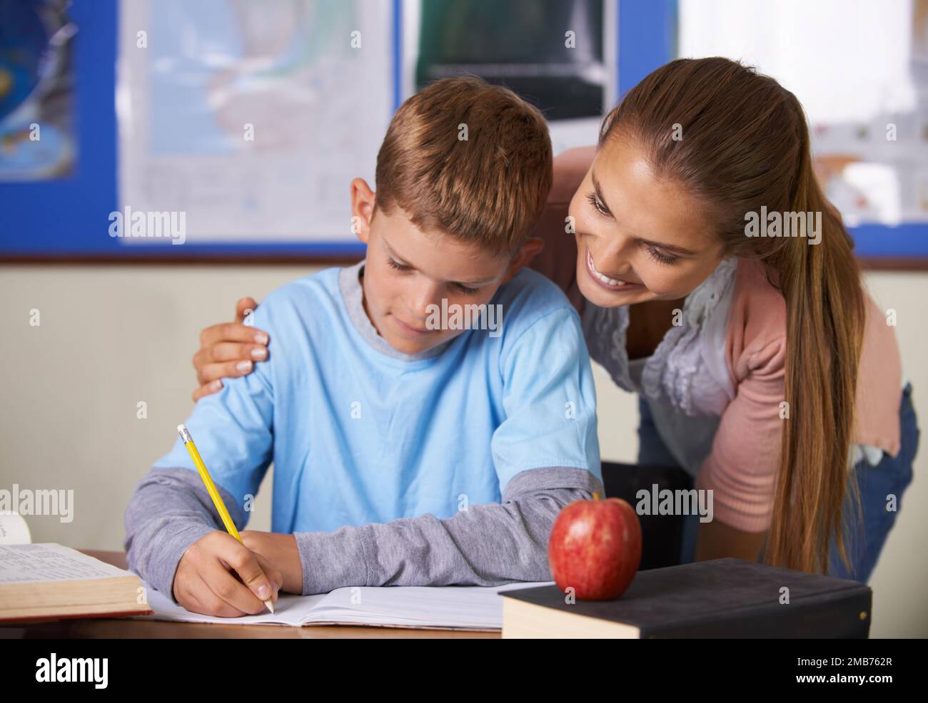 Helping him to write his own future. A supportive young teacher leaning ...