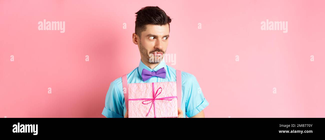 Holidays and celebration concept. Shocked guy staring aside with cringe ...