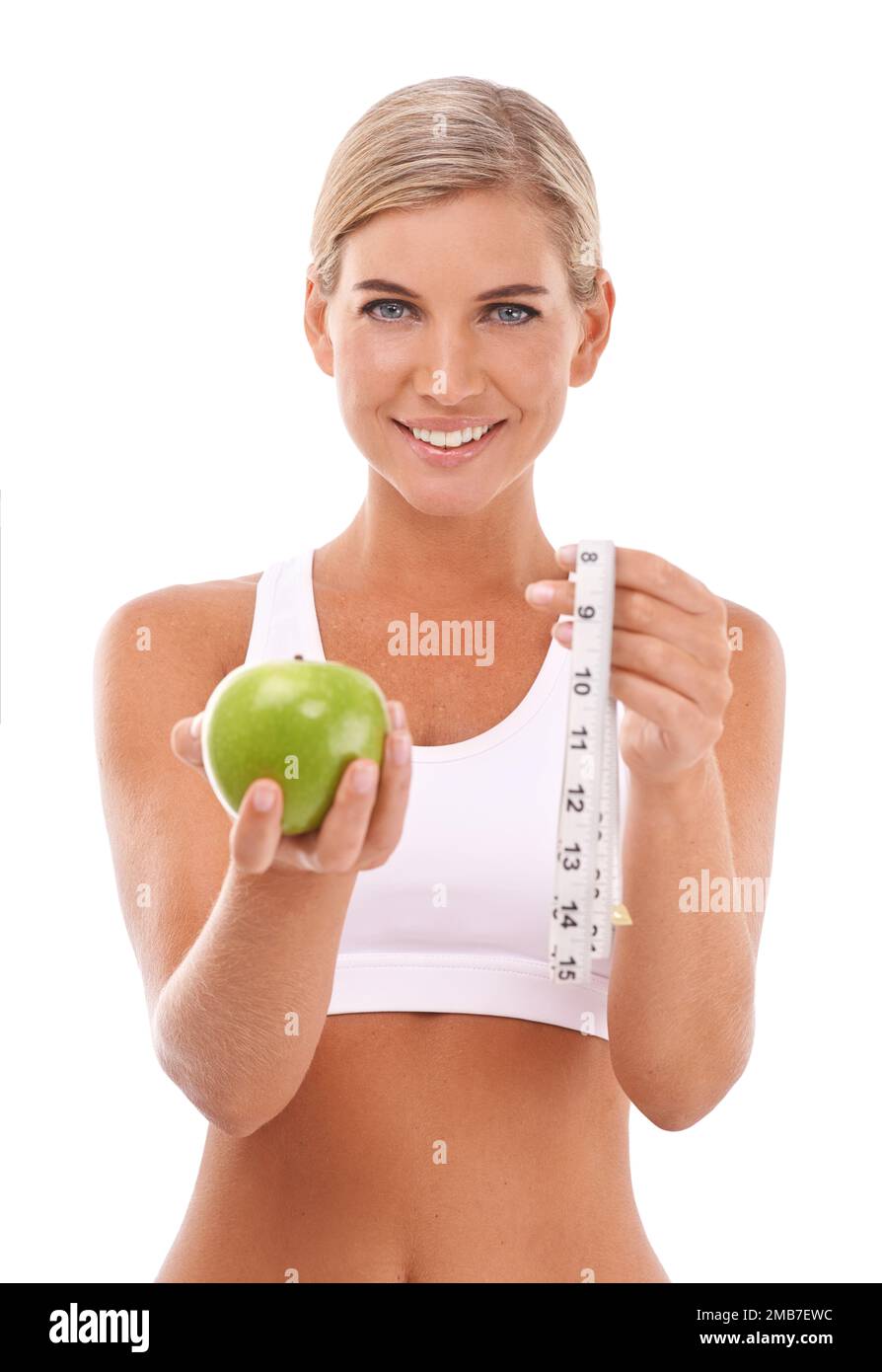 Woman, studio portrait and apple with measure tape for wellness, diet ...