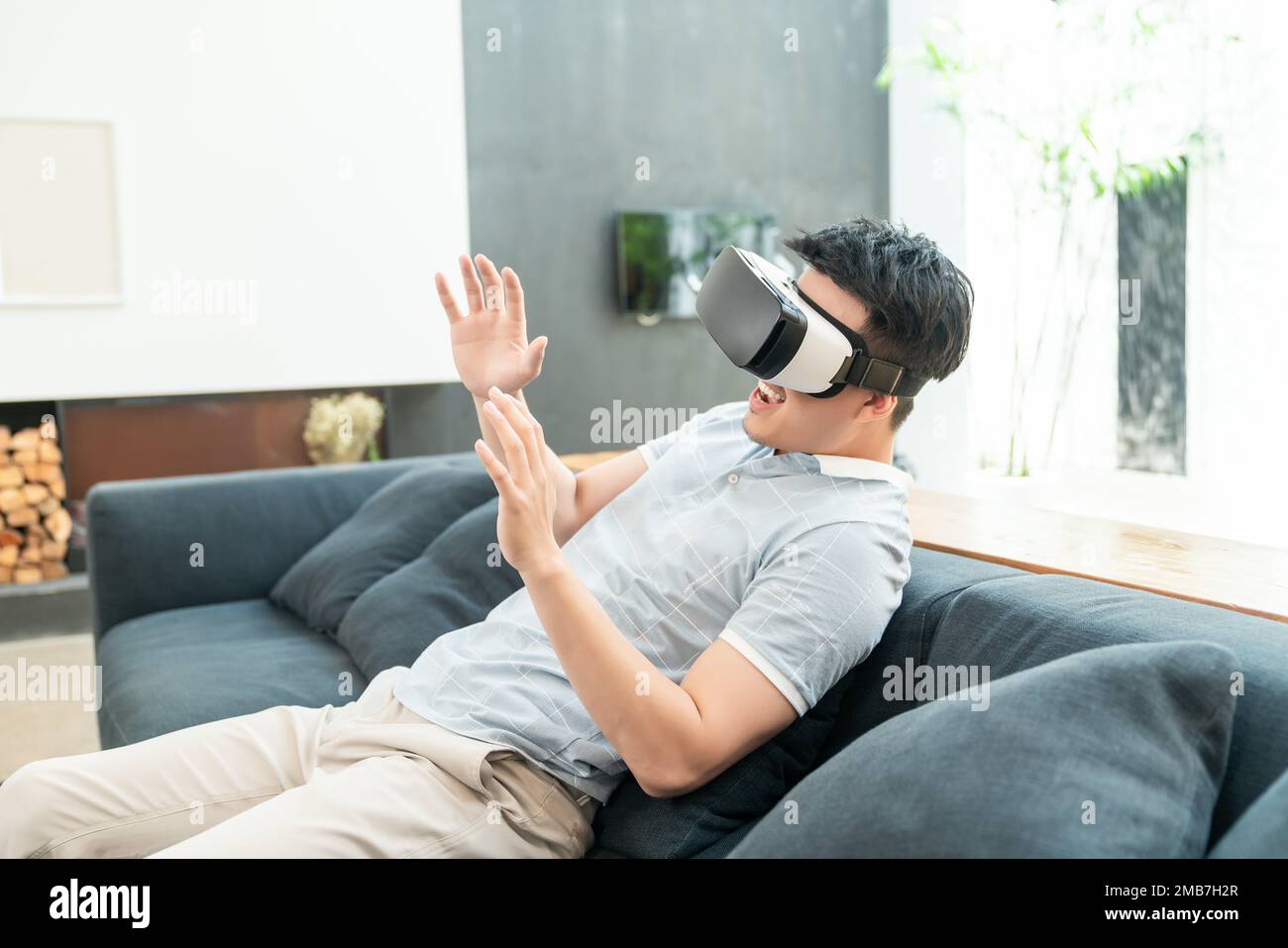 The young man on the sofa to use VR glasses Stock Photo - Alamy