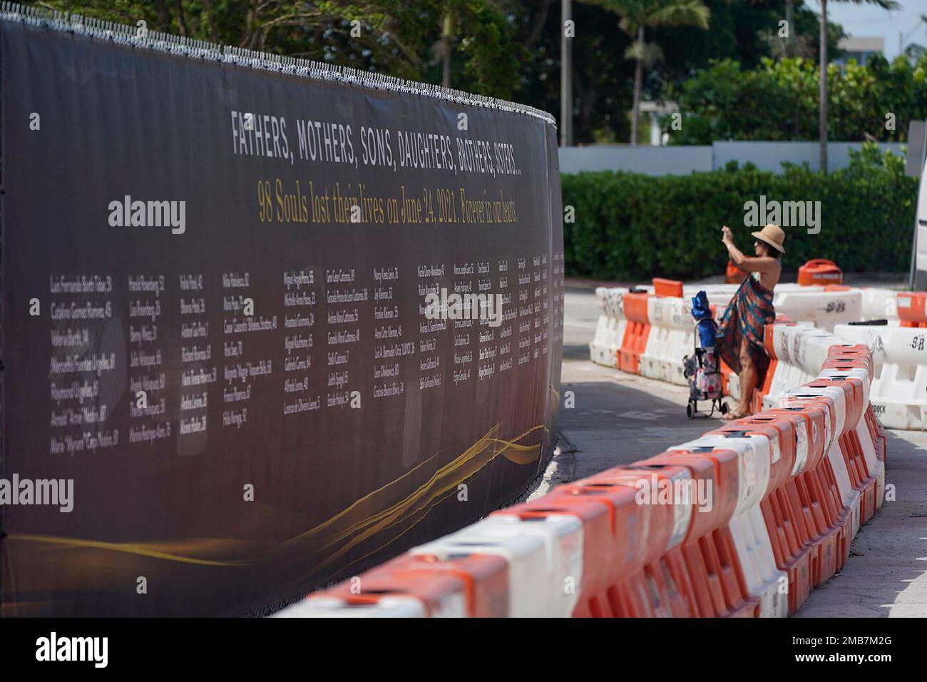 A beach goer takes a photo of a banner surrounding the site where the ...