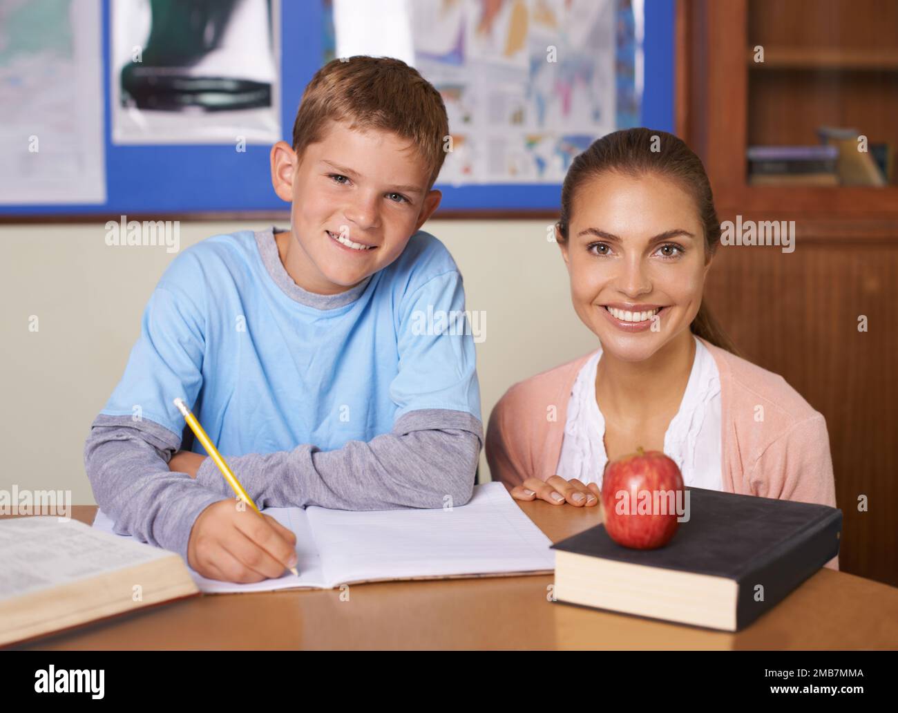 Encouraging a love of learning. A supportive young teacher sitting next ...