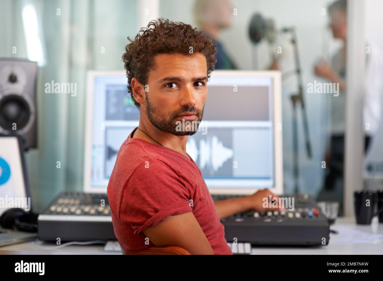 Taking time to perfect the recording...A handsome young sound engineer ...