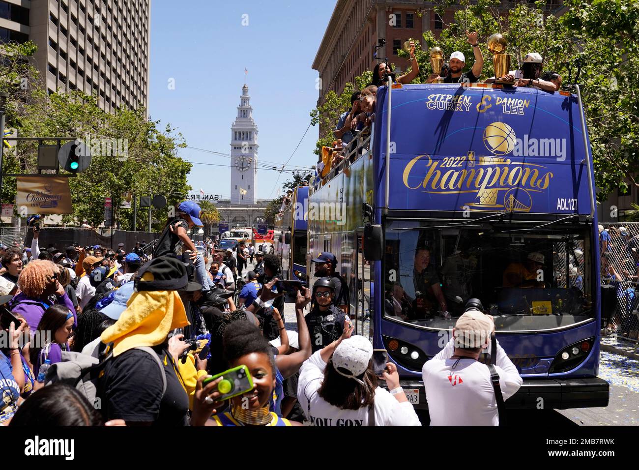 Stephen Curry and Damion Lee, right, ride atop a bus during the Golden ...