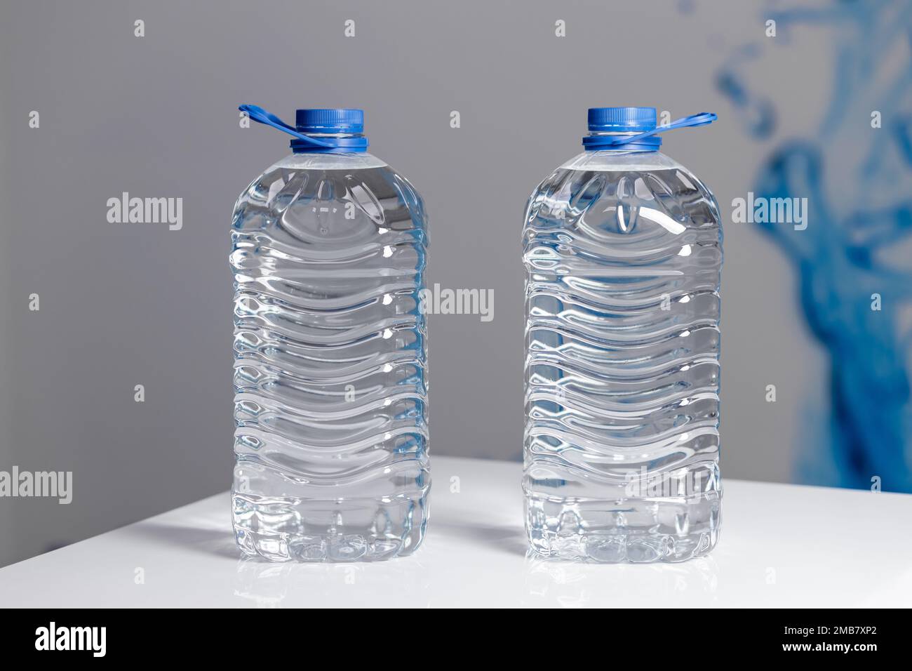 Two full 5 liter bottles of water on a white table. Water delivery ...