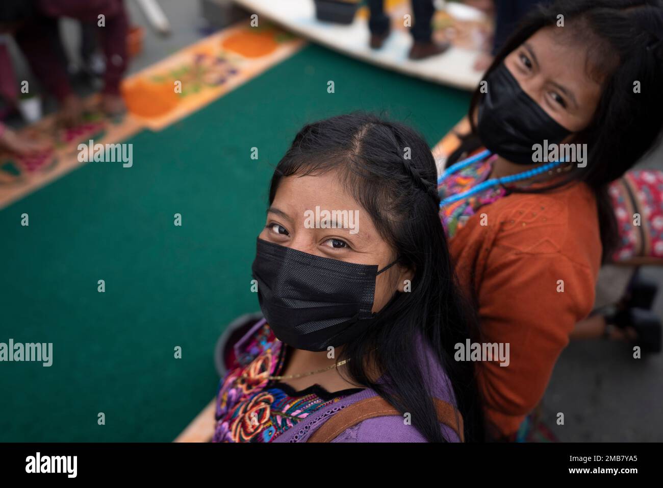 Indigenous women smile as they create carpets out of colored sand and ...